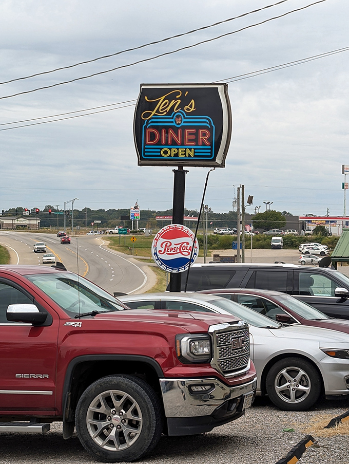 Jen's Diner's neon sign glows with the promise of comfort food classics, drawing hungry locals whose parked trucks testify to its popularity.