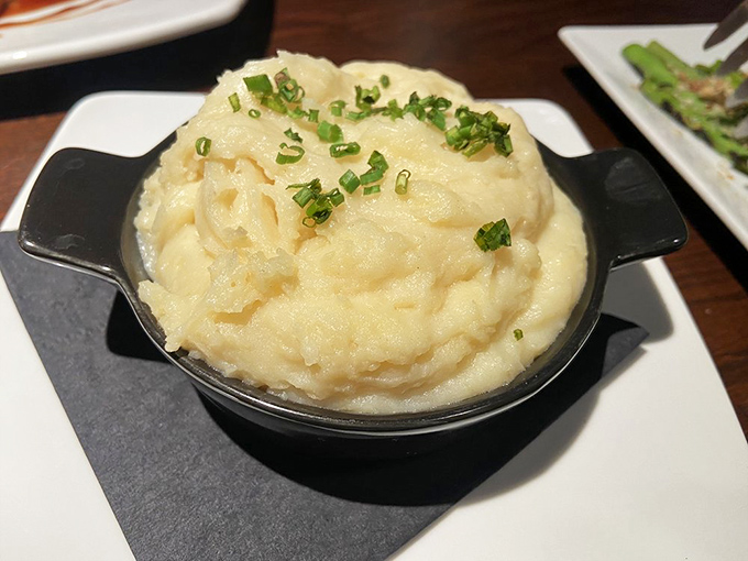 Mashed potatoes elevated to cloud-like perfection. That sprinkle of chives isn't garnish—it's the perfect finishing touch to comfort food reimagined.