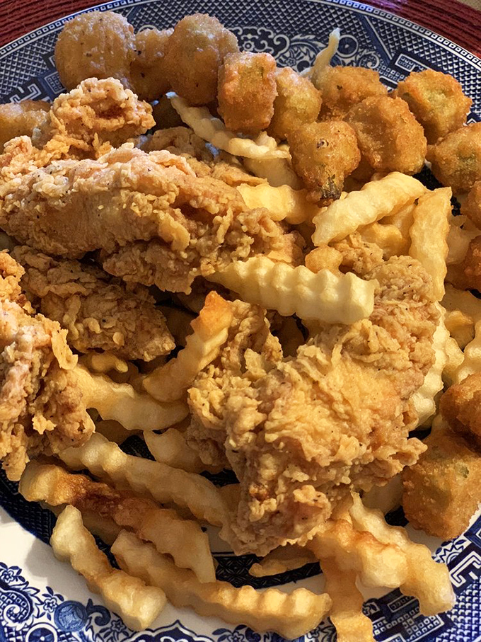 A blue willow plate piled high with fried treasures—like an archaeological dig where every discovery is more delicious than the last.