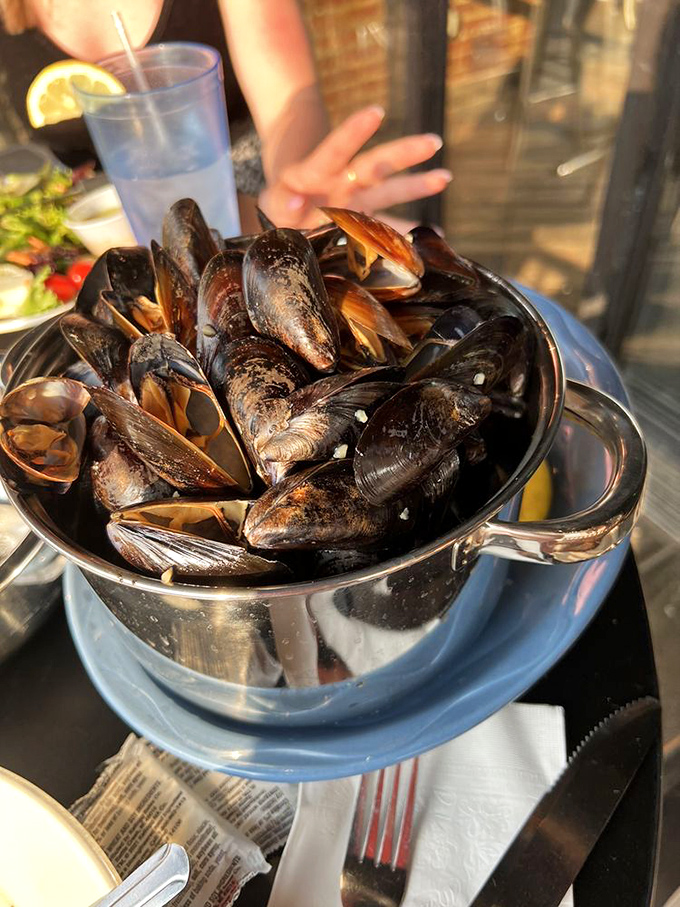 Mussels served in their natural habitat – a steaming pot of aromatic broth that you'll be sopping up with bread long after the shells are empty.