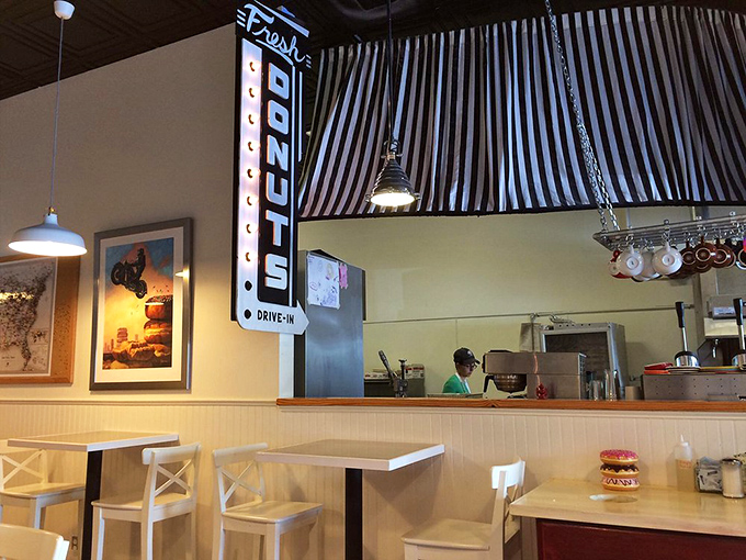 The black and white awning creates a classic diner feel, while the kitchen buzzes with donut-making magic.