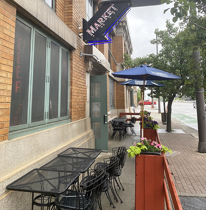 The sidewalk seating whispers, "Stay awhile," as planters burst with flowers and the market sign promises authentic Cleveland flavors just steps away.