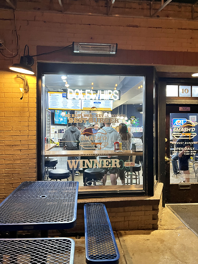 Peering through the window at night reveals the inner sanctum of smashed burger perfection. Those blue metal tables have witnessed countless first bites and wide-eyed reactions.
