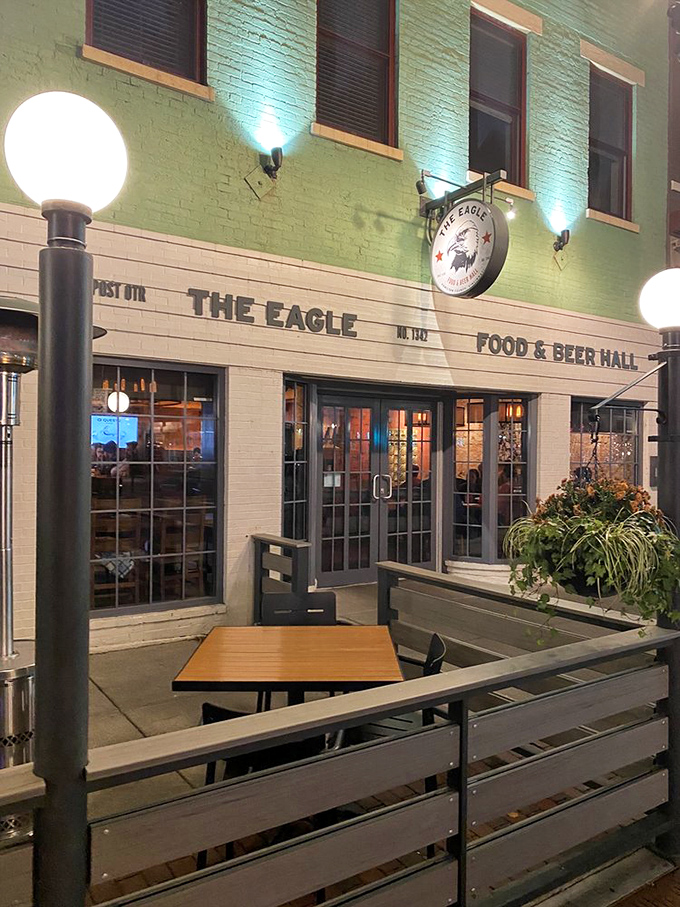 Evening transforms the patio into an urban oasis where the mint-green building glows invitingly, promising crispy, juicy treasures within.