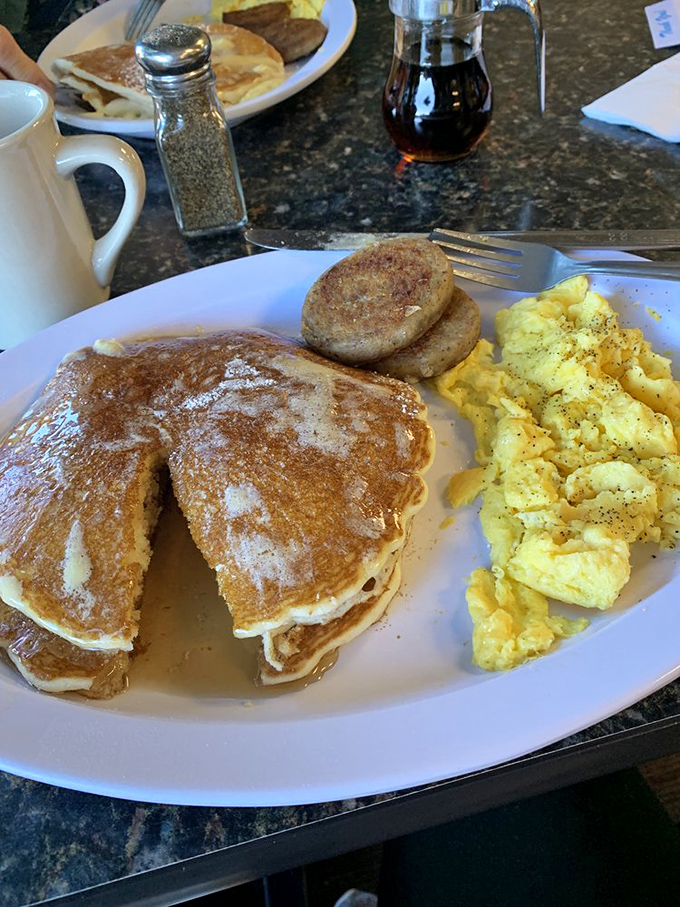 Pancakes stacked like golden discs of joy, with eggs scrambled to that elusive perfect consistency that chain restaurants can only dream about.