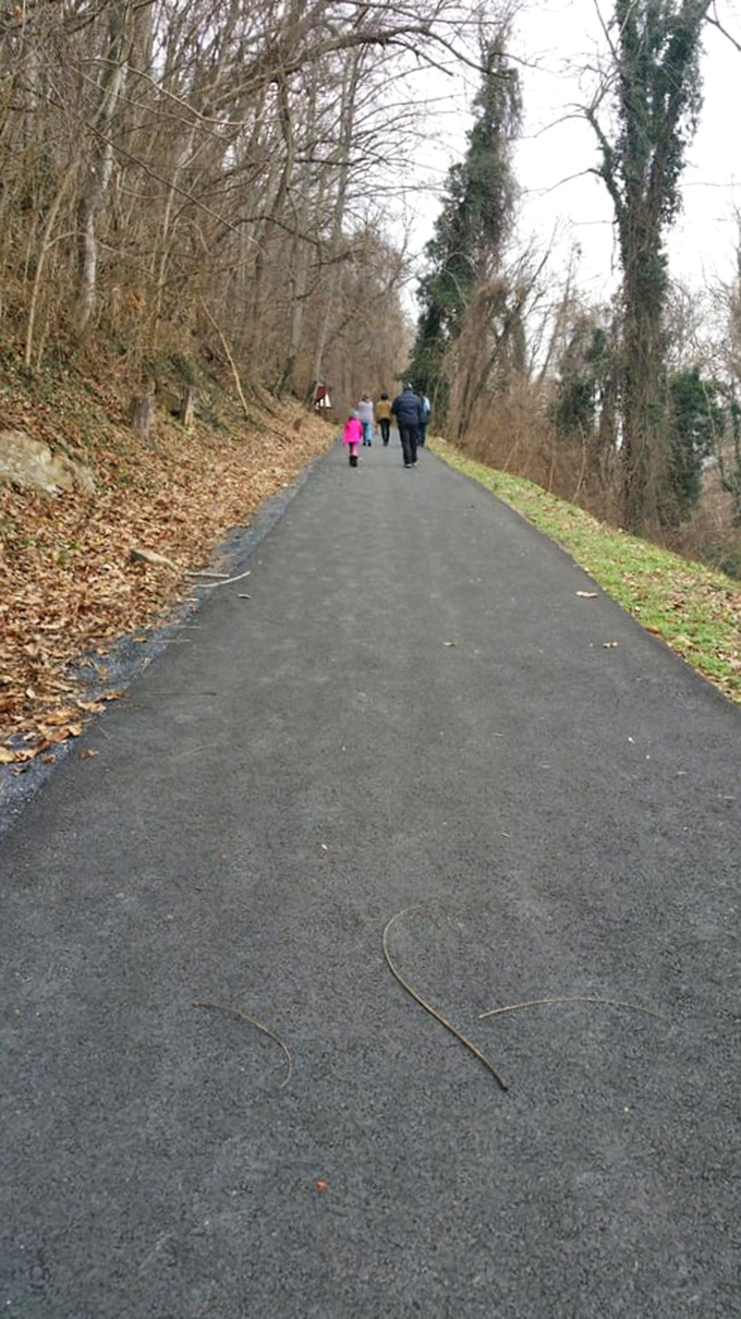 The path to underground wonders begins with this unassuming trail, where anticipation builds with every step toward the mountain.
