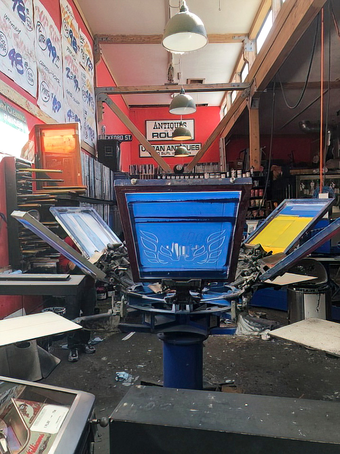 The screen printing equipment reveals Free Gold Watch's dual identity. By day, T-shirts; by night, the sweet symphony of pinball wizardry.