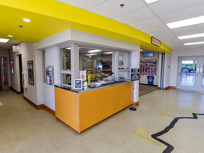 The bright yellow welcome desk serves as mission control for your journey through automotive history. The adventure begins with a friendly greeting.
