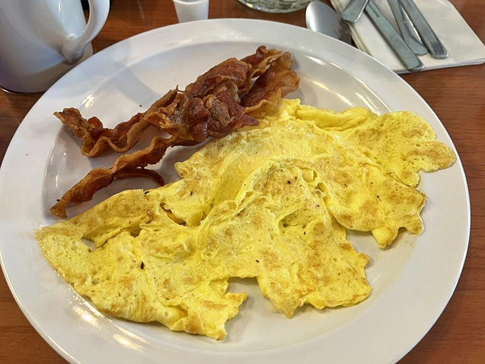 Scrambled eggs that actually look like eggs, not some pale yellow afterthought. Paired with bacon that's achieved crispy perfection.