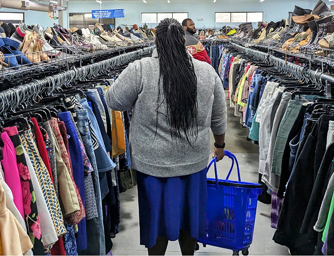 The serious business of thrifting in action. With basket in hand, this shopper navigates the clothing forest with the focus of a seasoned professional.