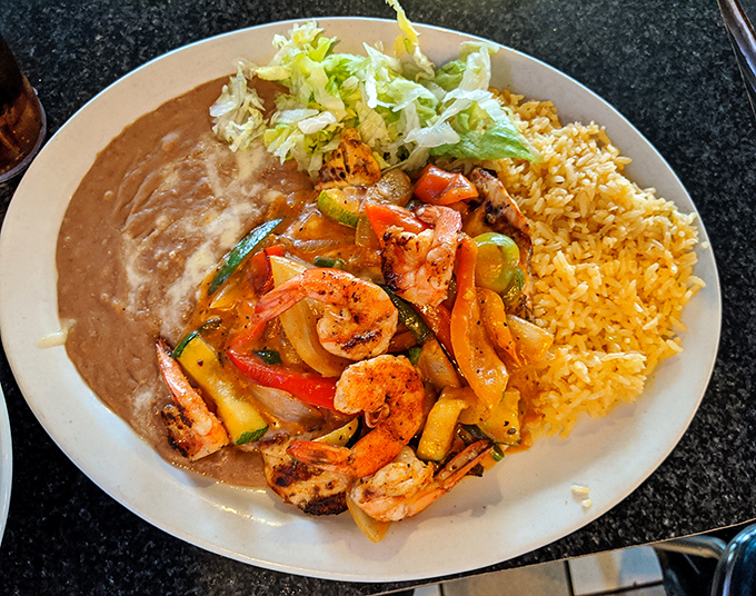 Sizzling shrimp fajitas with colorful peppers and onions&mdash;a plate that announces its arrival with both aroma and sound.