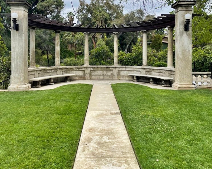 This curved colonnade with its pergola roof creates an outdoor room where you half expect to find Jane Austen characters discussing marriage proposals.