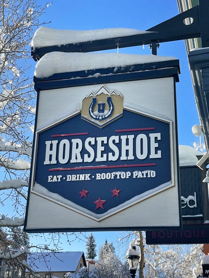 Even under a blanket of snow, this sign promises warmth inside. Colorado winters meet their match in Horseshoe's cozy embrace.