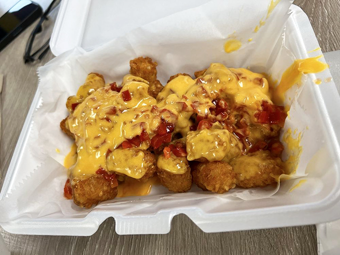 These cheese tots are having more fun than you are, swimming in a pool of cheese sauce and what appears to be chili bits.