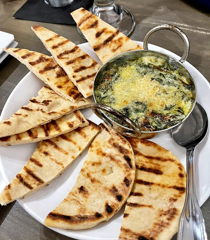 Spinach dip that demands to be scooped up with grilled flatbread. The kind of appetizer that ruins friendships when the last bite disappears.