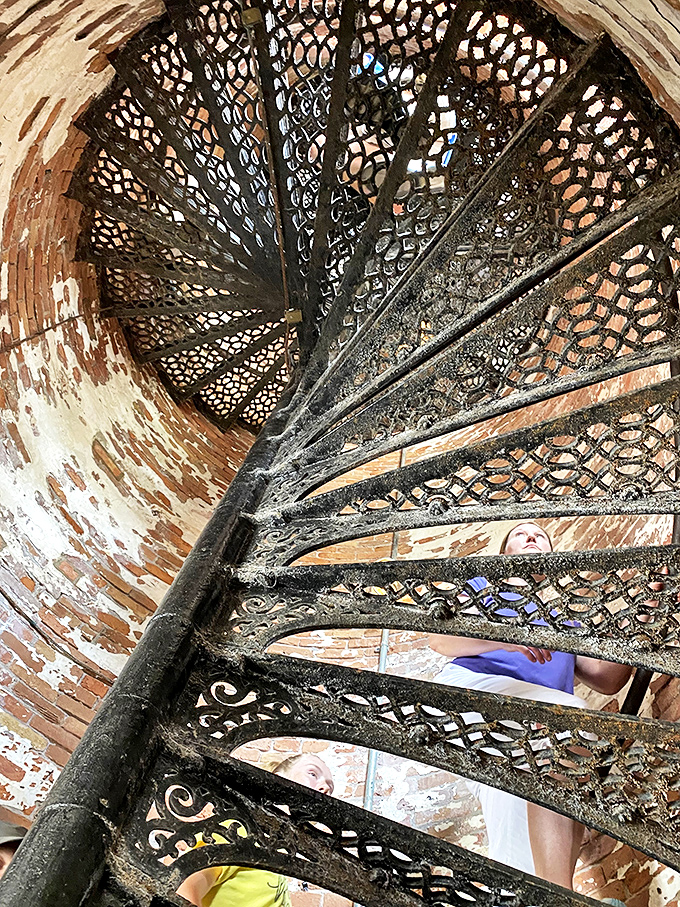 The lighthouse's original cast iron staircase spirals upward like a nautical DNA strand, worn smooth by two centuries of keepers and curious visitors.