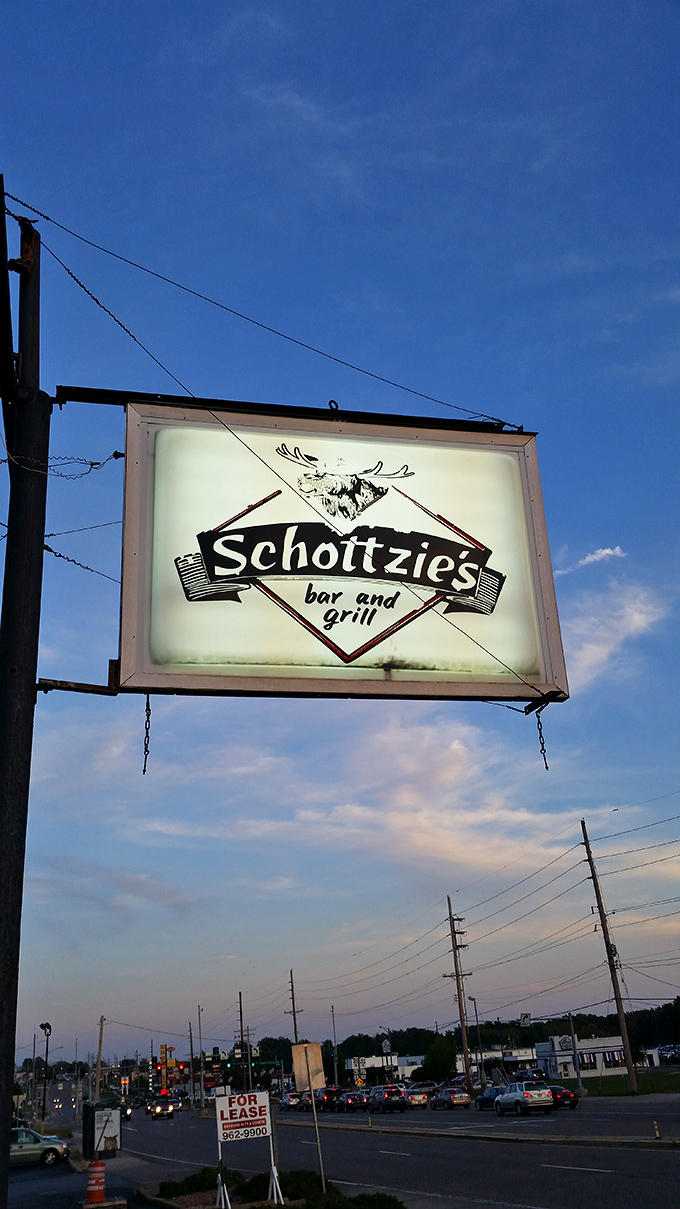The illuminated sign stands like a beacon against the twilight sky, promising honest food and cold drinks to those wise enough to stop.