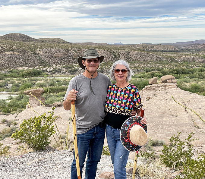 Hiking partners who've discovered the fountain of youth in desert adventures. Their walking sticks say "prepared," but their smiles say "this beats bingo night."