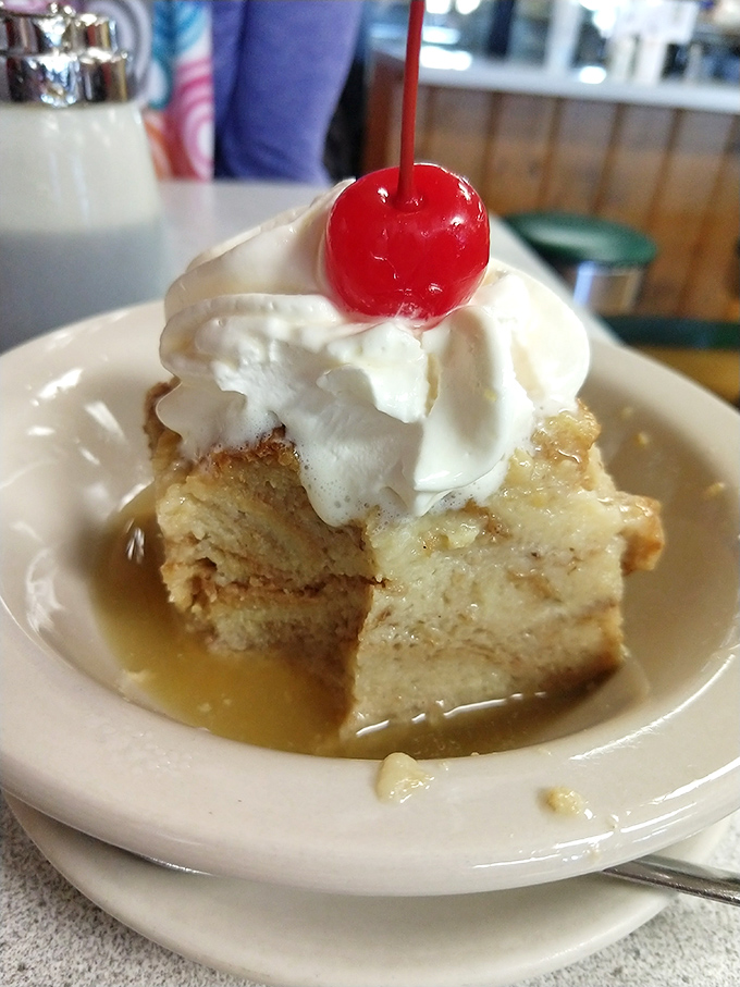 Bread pudding swimming in sweet syrup, crowned with whipped cream and a cherry&mdash;dessert masquerading as breakfast, and nobody's complaining.
