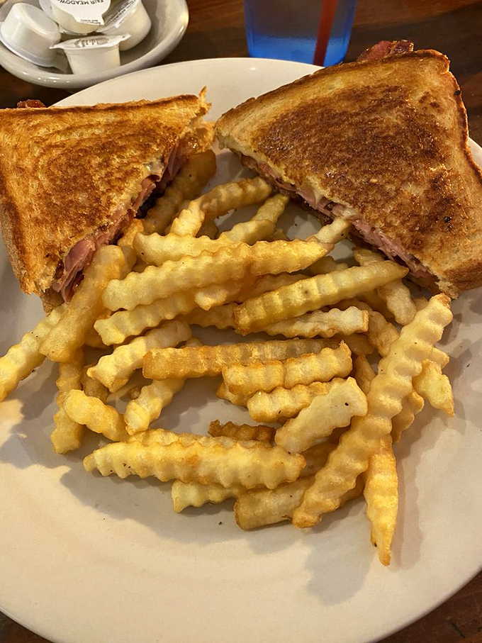 A grilled sandwich and crinkle fries that together form the universal language of "you're going to need a nap after this, and it will be worth it."