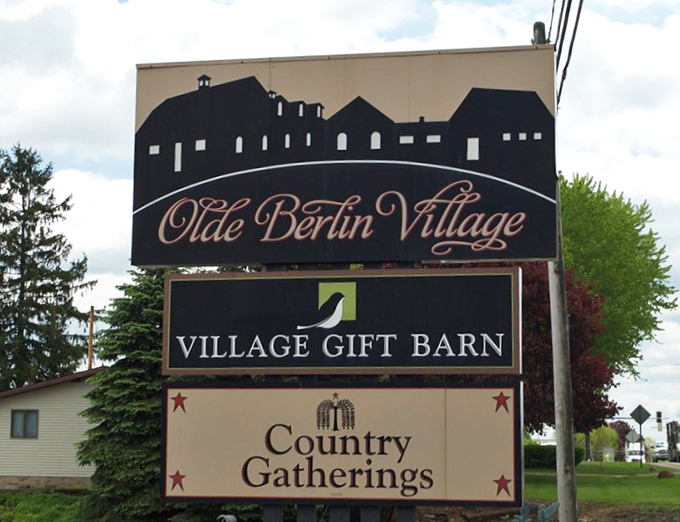 The Village Gift Barn sign stands as a beacon for shoppers seeking everything from practical souvenirs to whimsical treasures that spark joy.