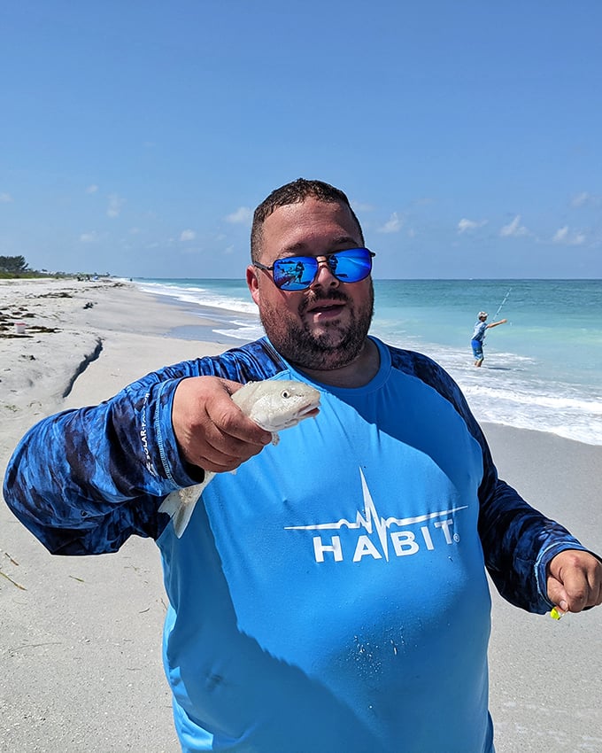 Victory at sea! This proud angler displays his catch with the kind of smile that says, "Tonight we feast, tomorrow we fish again."