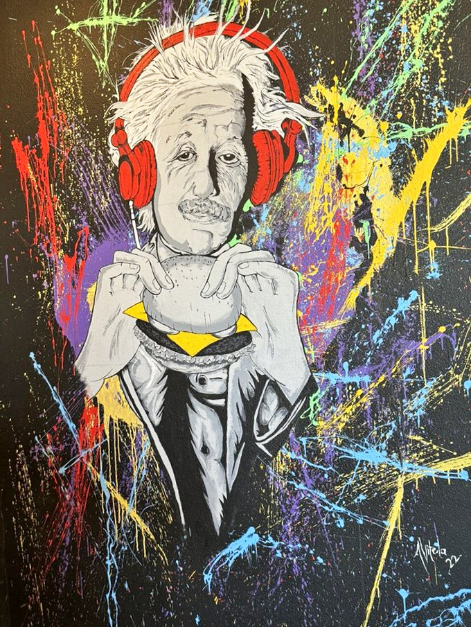 Einstein enjoying a burger with headphones on&mdash;because even geniuses know that sometimes the simplest pleasures require your full attention.
