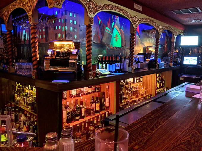 Behind the bar, where bottles gleam like treasure and Venetian arches frame liquid possibilities, bartenders craft drinks that have outlasted decades of passing trends.