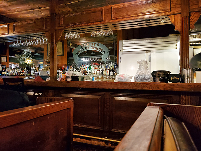 The bar area glows with amber warmth, bottles lined up like soldiers ready to enhance your meal with liquid companionship.