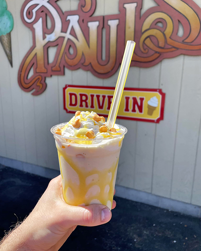 A butterscotch masterpiece proudly displayed against the Paul's Drive In sign. This shake isn't just a drink&mdash;it's liquid nostalgia with whipped cream on top.