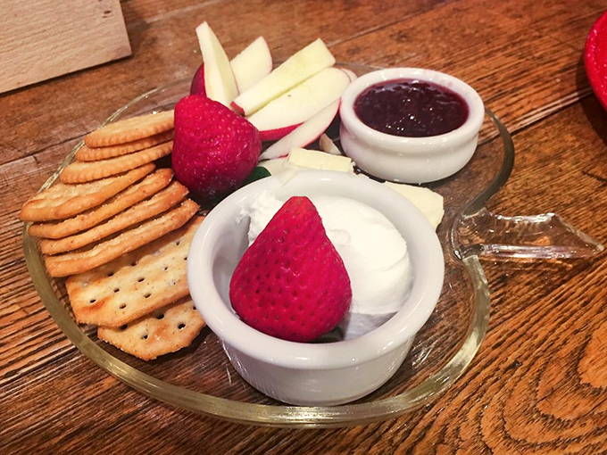 The cheese plate arrives like a still life painting you can eat – crackers, fruit, and creamy cheese creating the perfect prelude to pie paradise.