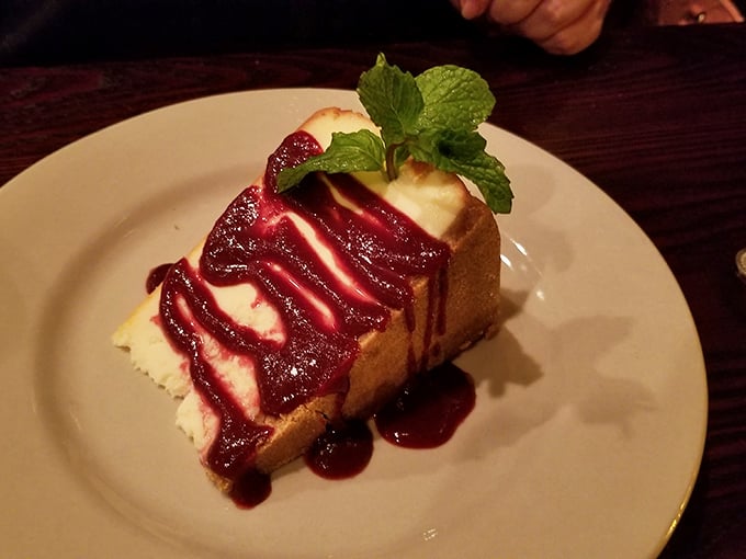 Cheesecake with berry coulis and a mint sprig—because every epic meat feast deserves a sweet finale that's equally indulgent.
