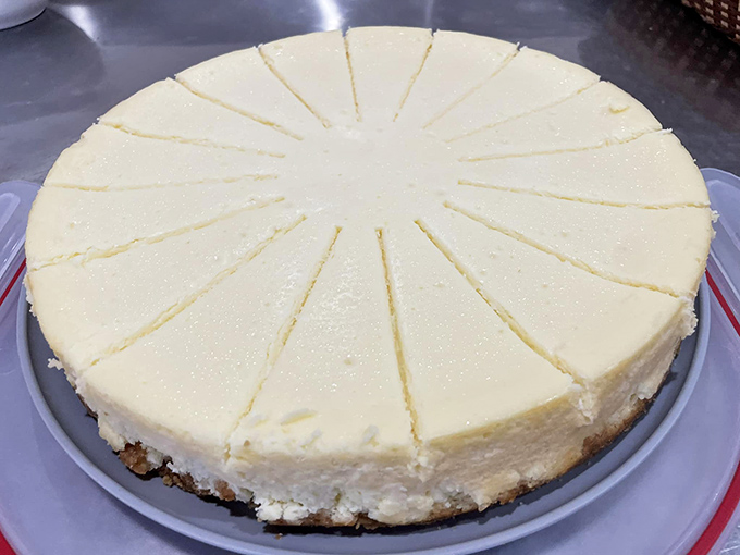 A cheesecake cut with mathematical precision, promising the kind of creamy, rich experience that makes diets temporarily disappear.