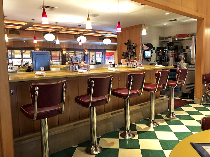 Those burgundy counter stools have witnessed more food confessions than a priest on Easter Sunday. The checkered floor adds a touch of '50s nostalgia.