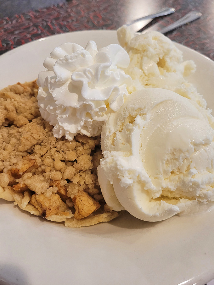 Apple crumble à la mode—where warm meets cold in perfect harmony. That scoop of vanilla isn't melting—it's swooning over its cinnamon-spiced companion.