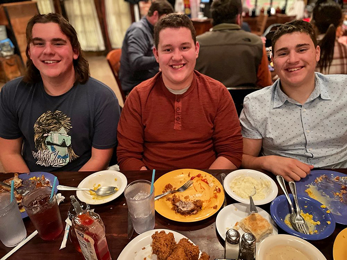 Three smiles that say it all: mission accomplished. The aftermath of a Babe's feast &ndash; empty plates, full hearts, can't lose.