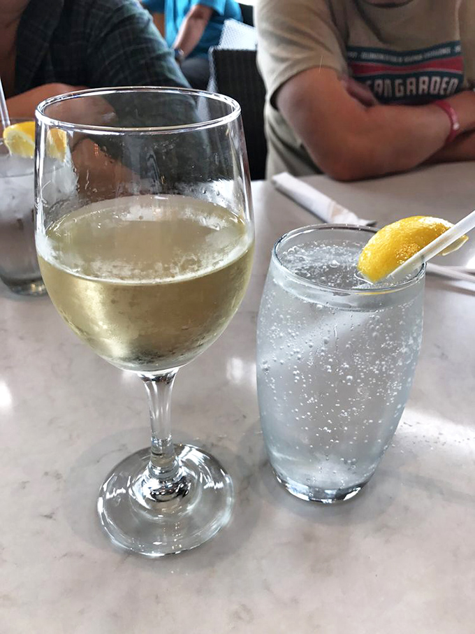 A crisp glass of white wine alongside sparkling water&mdash;because proper hydration is important when embarking on a serious seafood expedition.
