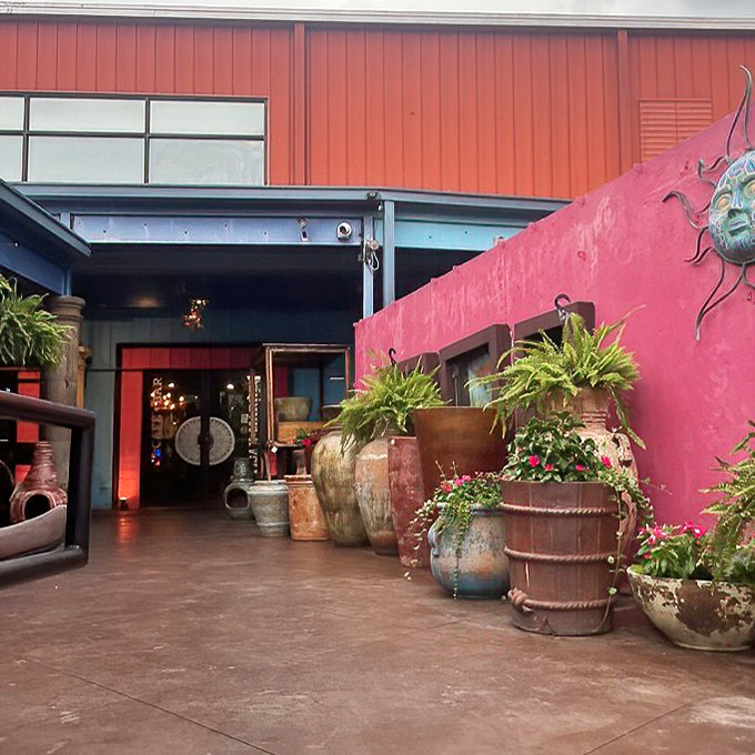 The entrance pathway, lined with colorful pottery and vibrant walls, sets the stage for the sensory fiesta that awaits just beyond those doors.