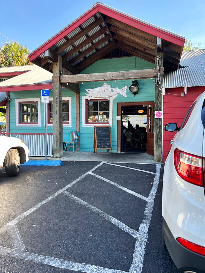 The turquoise and red entrance stands like a cheerful sentinel, with a fish silhouette above the door practically winking at hungry visitors.