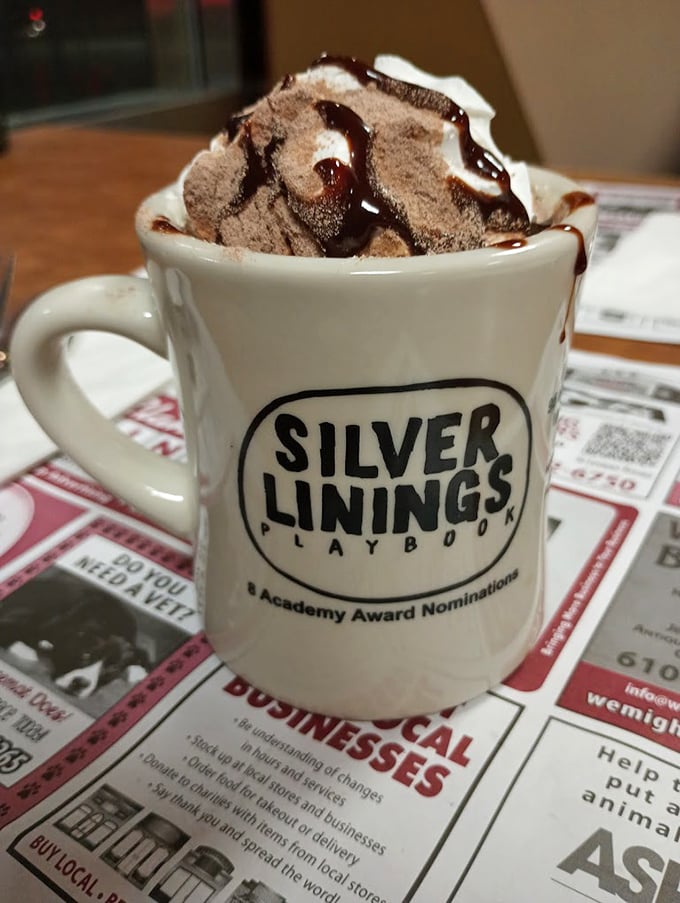 
Hot chocolate served with cinematic flair&mdash;the "Silver Linings" mug nodding to the diner's movie fame while whipped cream and chocolate drizzle steal the scene. 