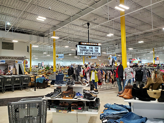 Warehouse cathedral of commerce buzzes with shoppers discovering that one person's donation becomes another's perfect treasure.
