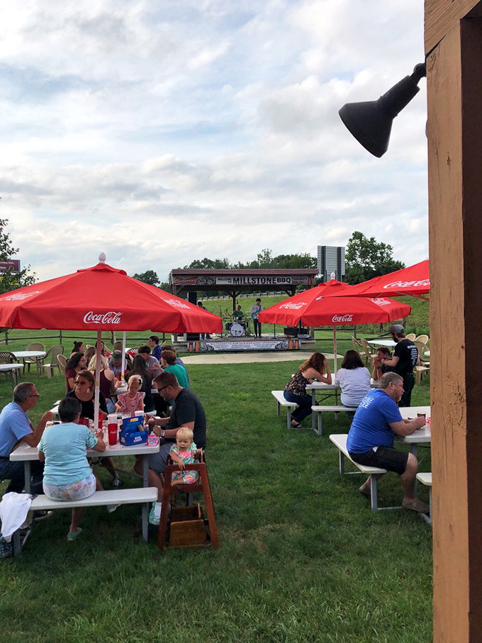 Live music and red umbrellas create the perfect backdrop for an evening where barbecue, community, and melody harmonize beautifully.