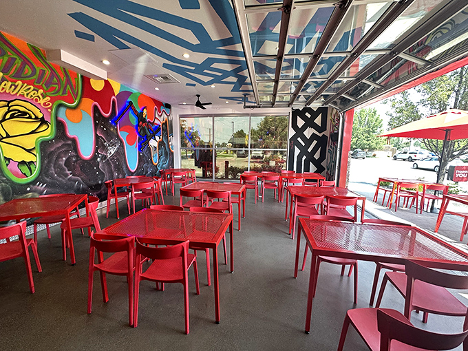 The outdoor seating area, with its signature red tables, offers a perfect spot to recover between bites of Nashville-inspired heat.