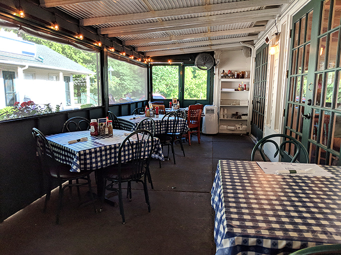 The screened porch dining area offers a perfect compromise between indoors and out. Those blue-checked tablecloths practically guarantee good food is coming.