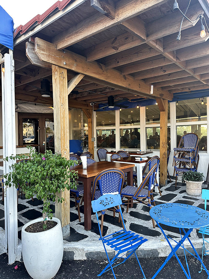 The outdoor seating area whispers "stay awhile" in blue and white. Those chairs have heard a thousand "Opas!" and are ready for yours.