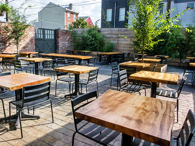 An outdoor oasis in urban Philadelphia. The patio's wooden tables invite you to linger over coffee, cocktails, or conversation beneath the city sky.