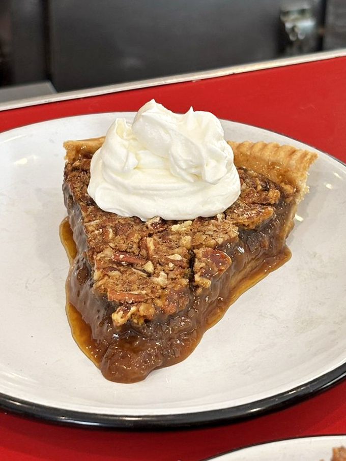 Pecan pie that makes time stand still—gooey, nutty, and topped with a cloud of whipped cream that's basically dessert's halo.