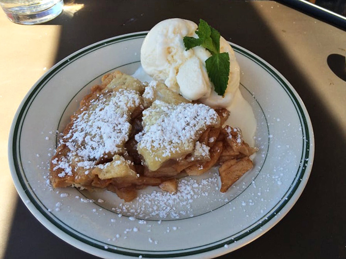 The apple fritter arrives dusted with powdered sugar snow and crowned with ice cream &ndash; dessert architecture that would make Frank Lloyd Wright weep with joy.