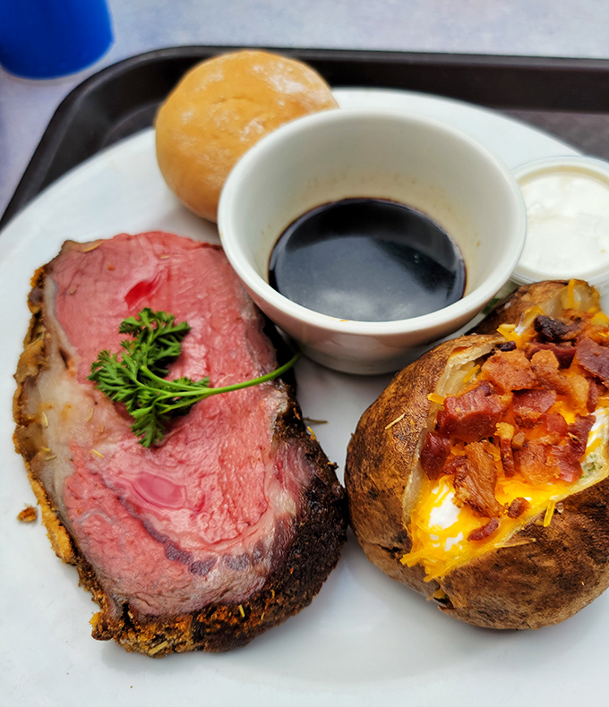 Prime rib cooked to that magical place between rare and medium-rare, alongside a baked potato that's clearly living its best life.