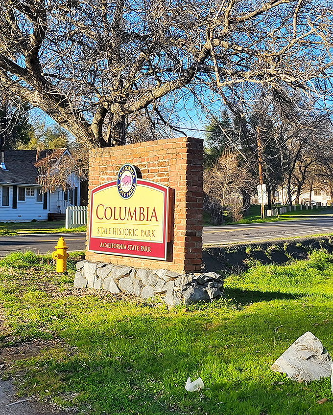 The park entrance sign welcomes visitors to California's golden legacy, a brick-and-mortar invitation to step across time's threshold.
